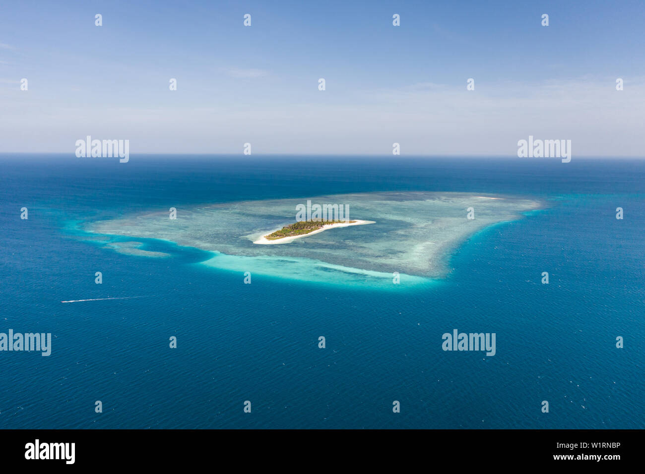 Tropical island Canimeran with sandy beach in the blue sea with coral ...