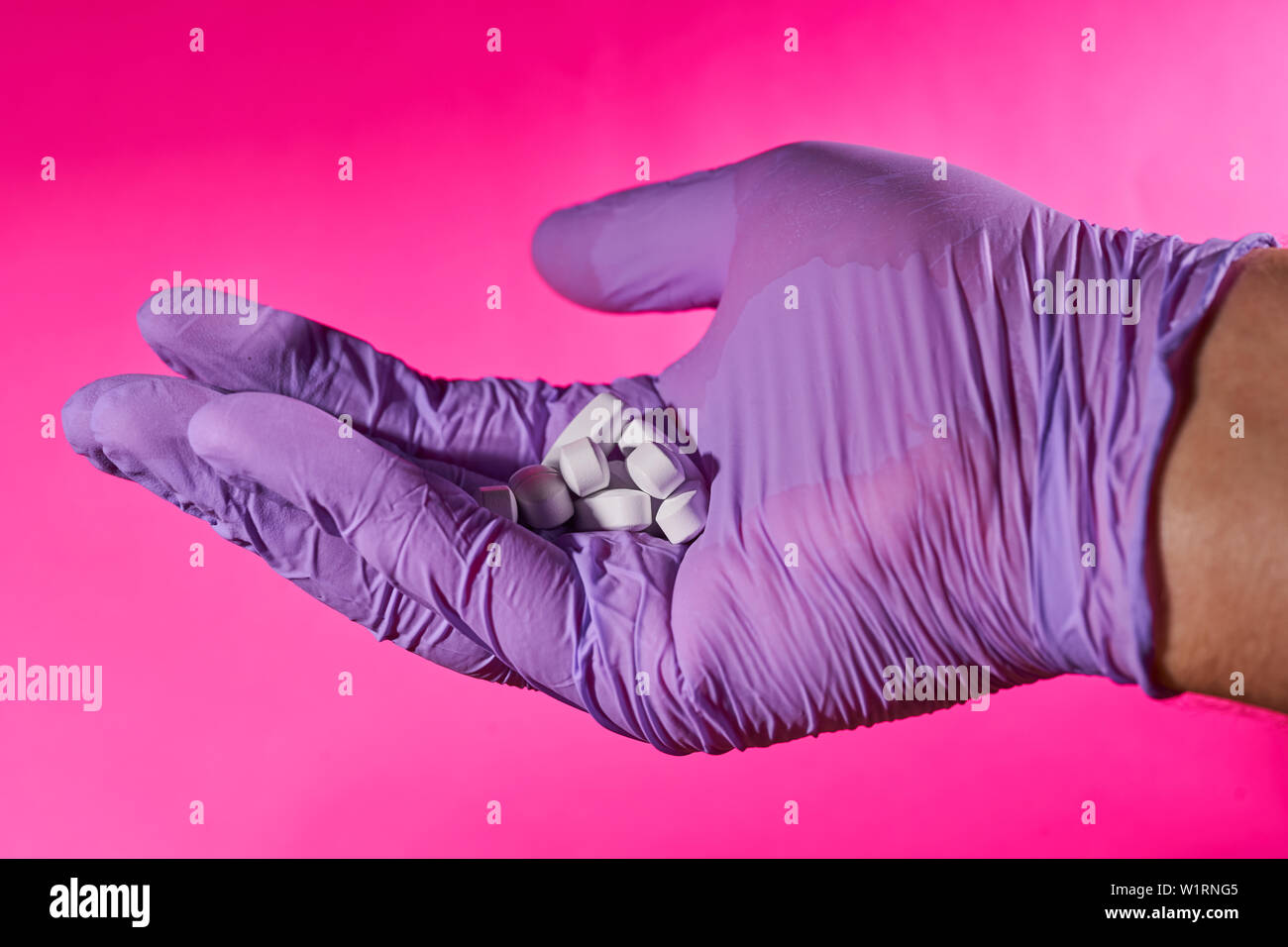 Gloved hand holding capsule hi-res stock photography and images - Alamy