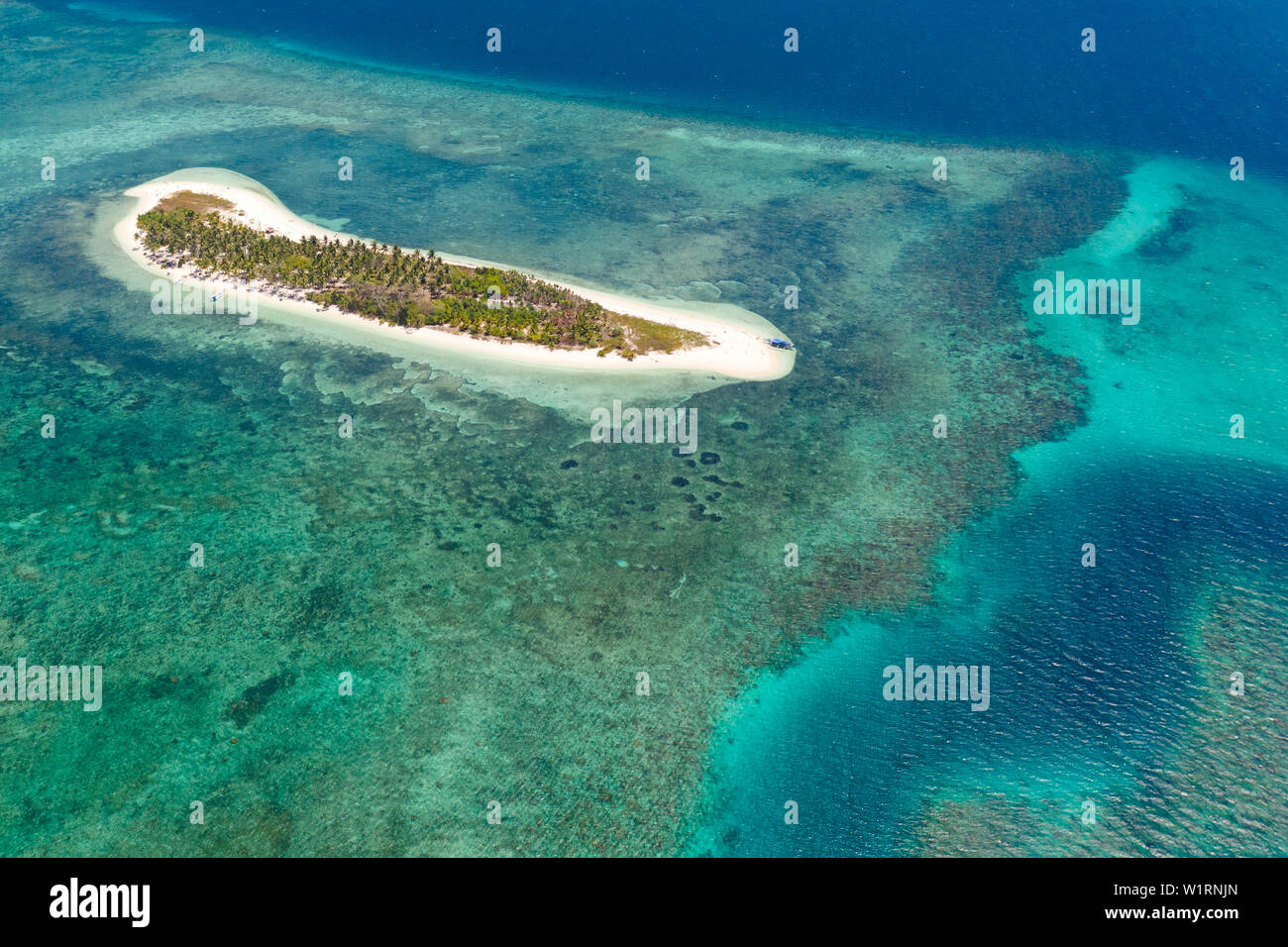 Tropical island Canimeran with sandy beach in the blue sea with coral ...