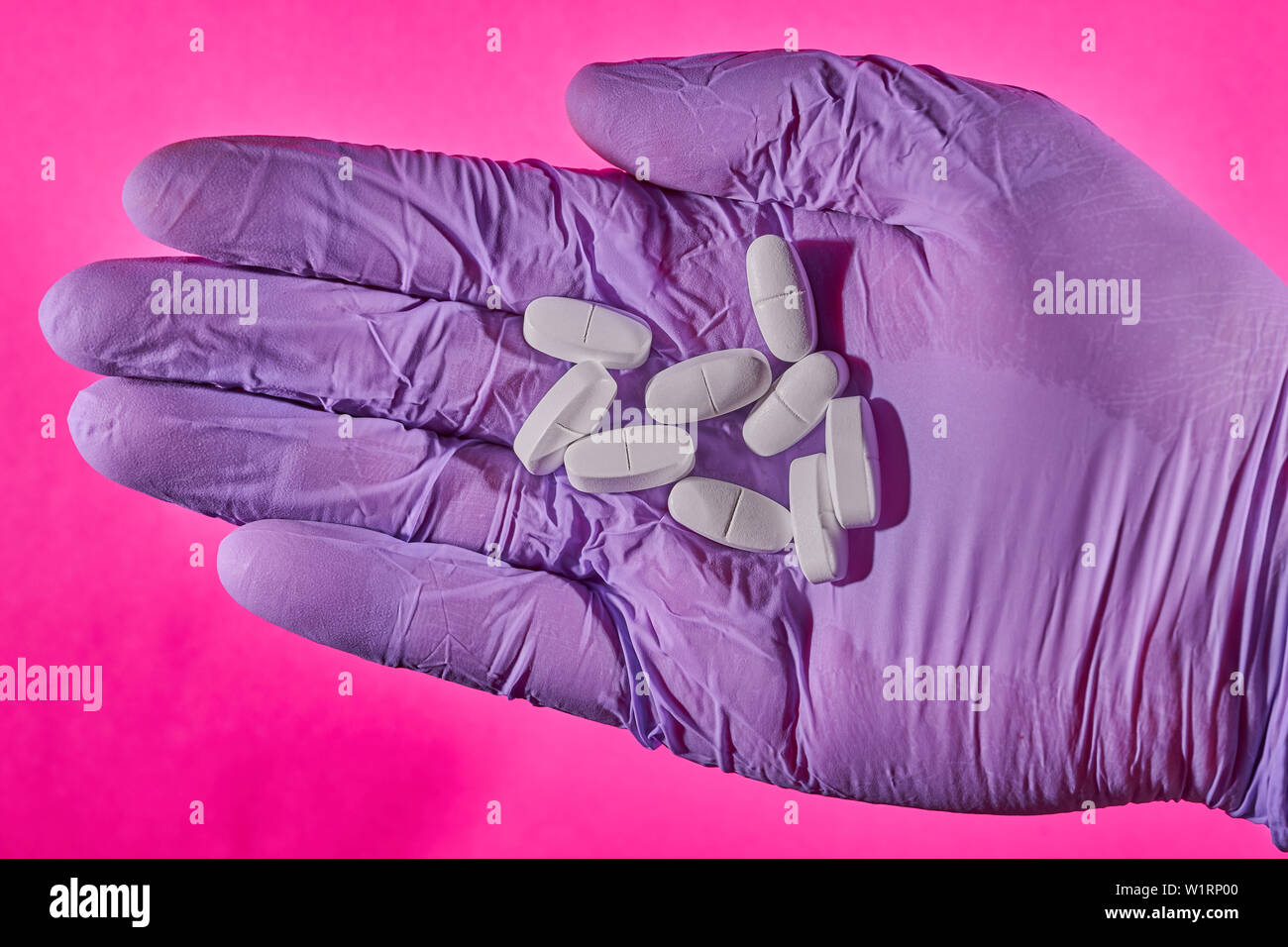 Gloved hand holding capsule hi-res stock photography and images - Alamy