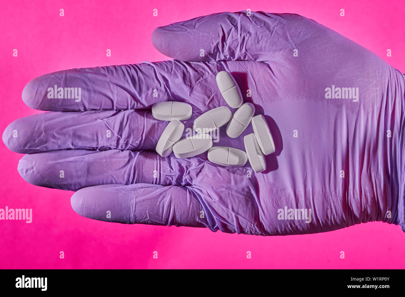 Gloved hand holding capsule hi-res stock photography and images - Alamy