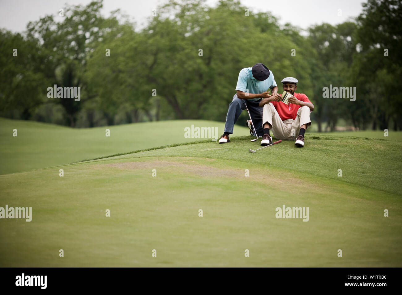 Men sitting on golf course with score card Stock Photo - Alamy