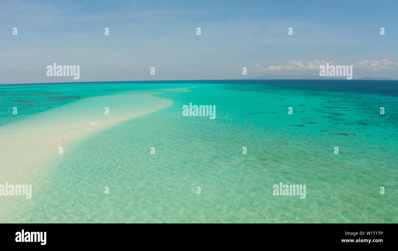 Island with a sandy beach and azure water surrounded by a coral reef ...