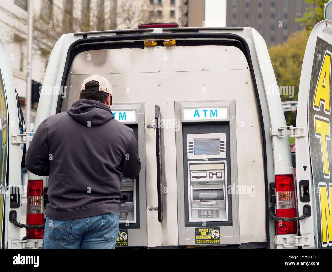 Man making a transaction at a mobile automated teller machine mounted ...