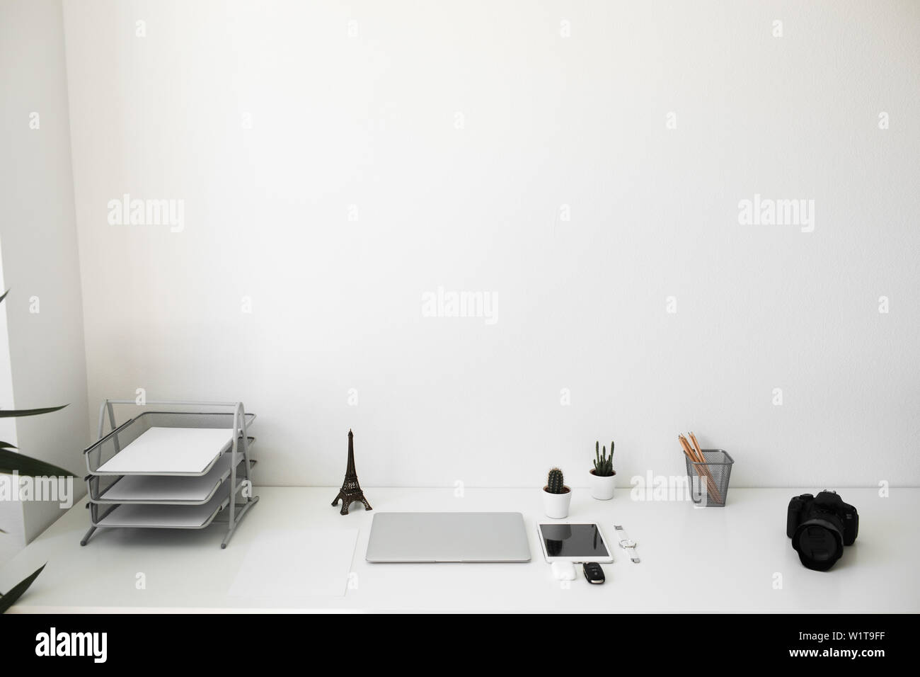 office table on which laptop, coffee, tablet, camera and other items ...