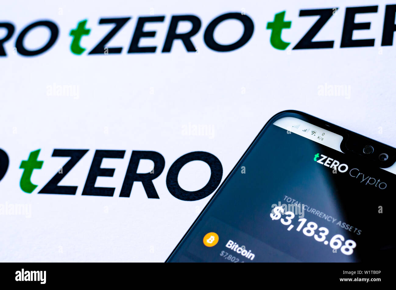 tZero logos on the brochure and the smartphone with the tZERO Crypto App screenshot Stock Photo ...