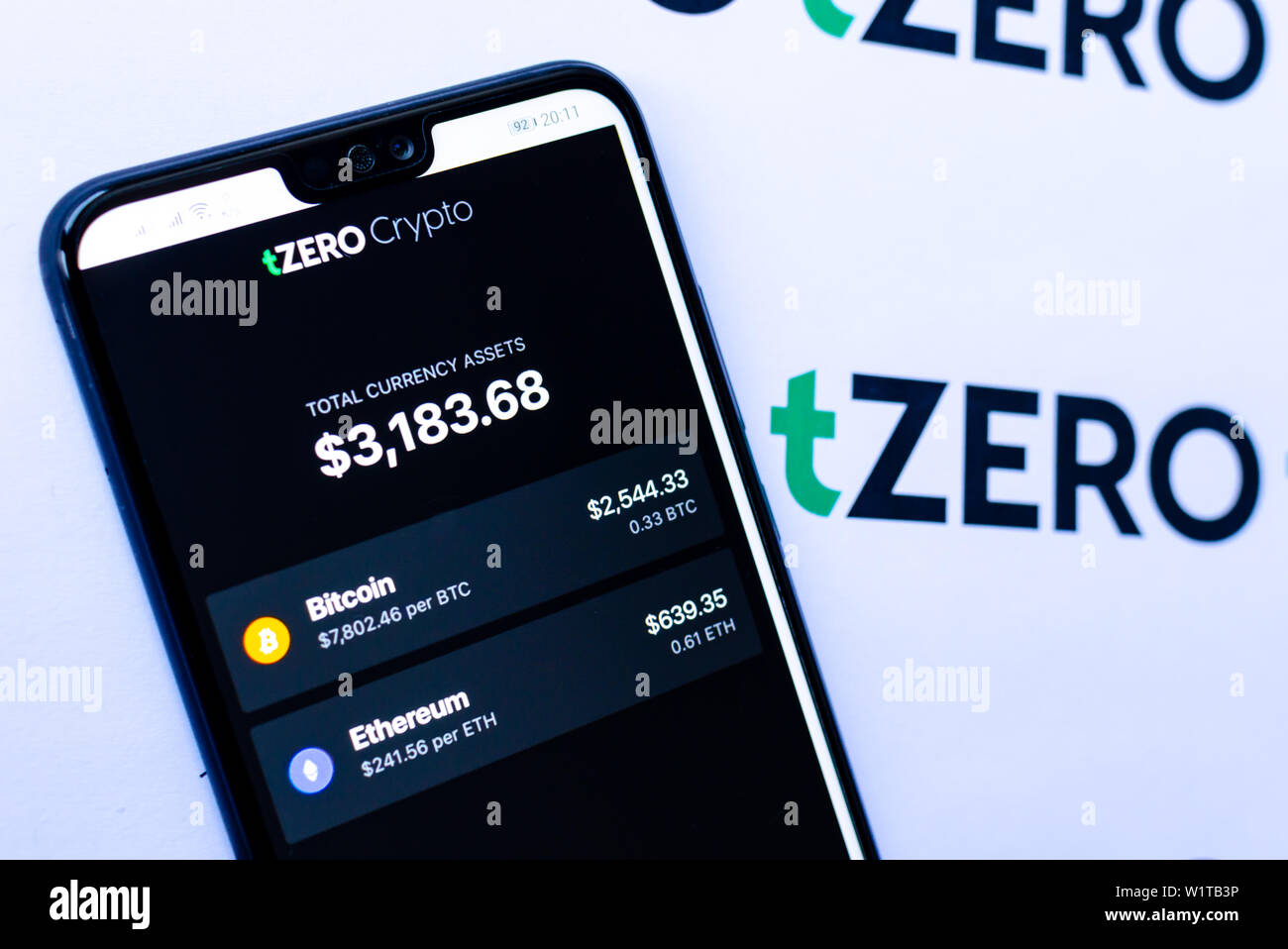 tZero logos on the brochure and the smartphone with the tZERO Crypto App screenshot Stock Photo ...