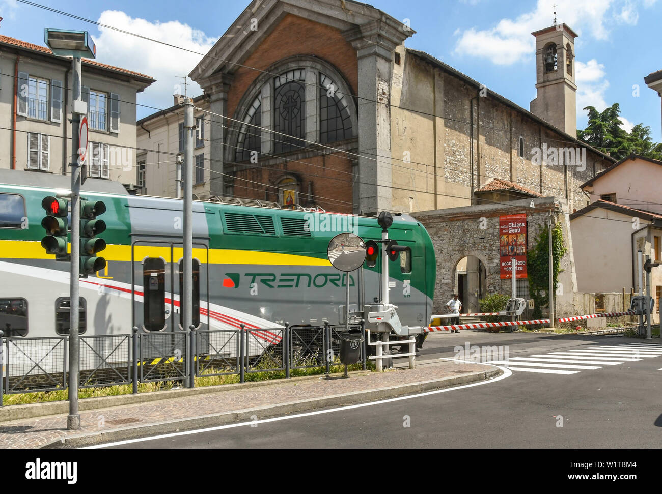 COMO, ITALY - JUNE 2019: Modern electric train passing over a road ...