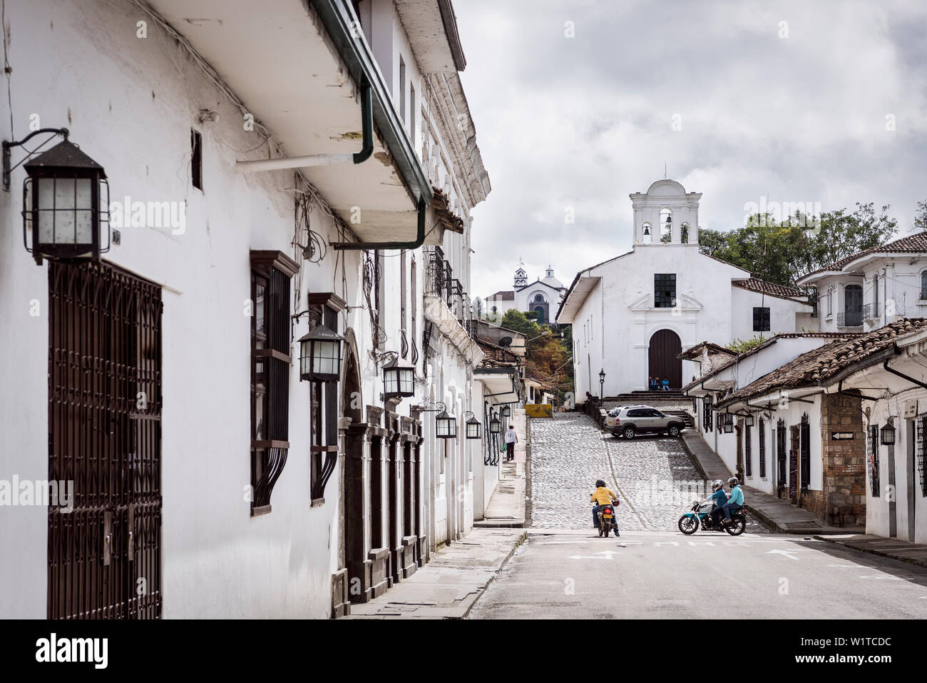 few small churches, colonial buildings and people on motorbikes ...