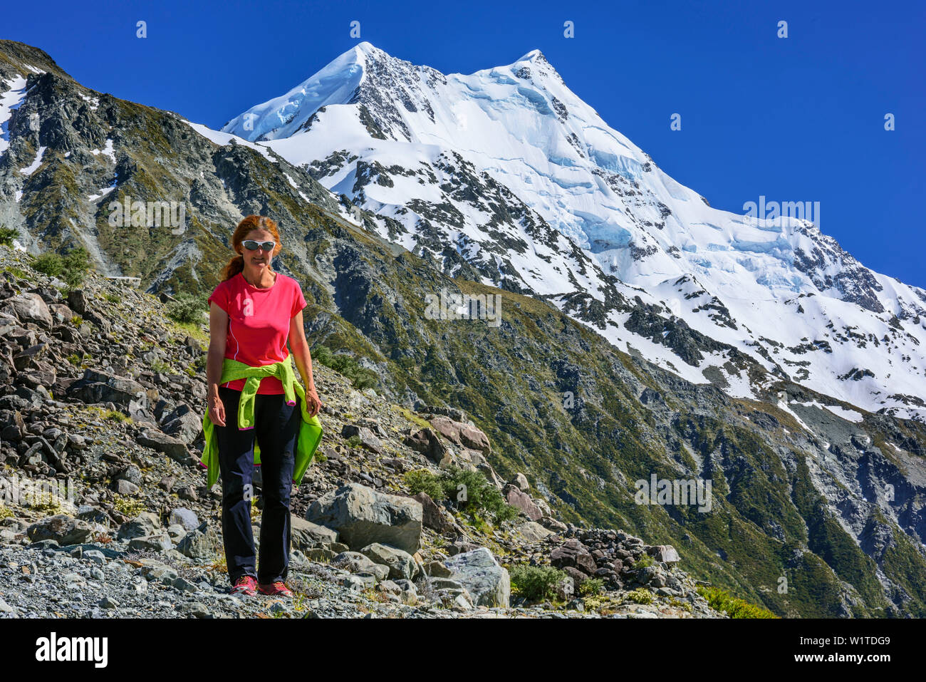 Woman hiking in Tasman Valley, mountains with glacier in background ...