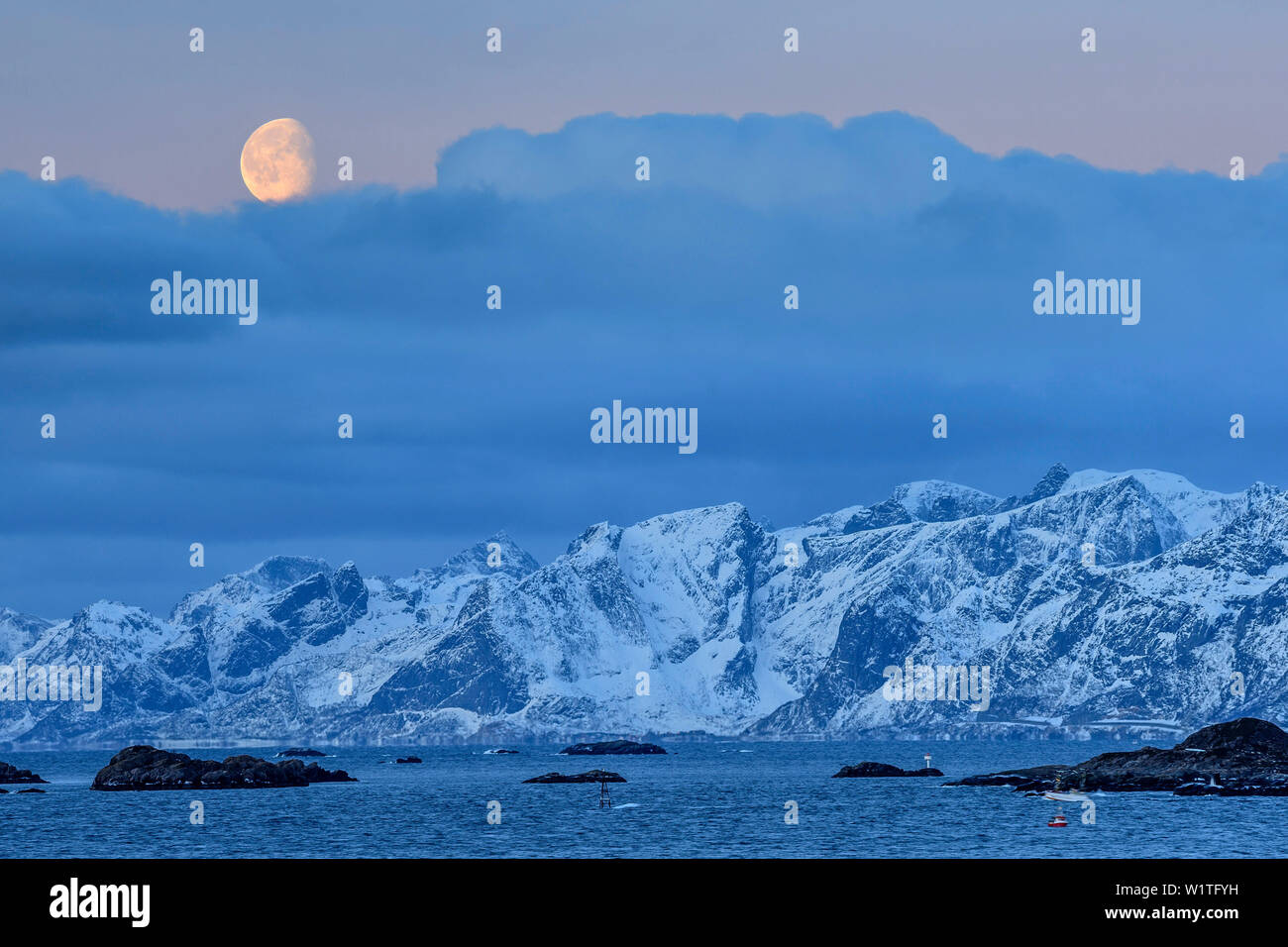Moon above snow-covered mountains and coast, Lofoten, Nordland, Norway ...