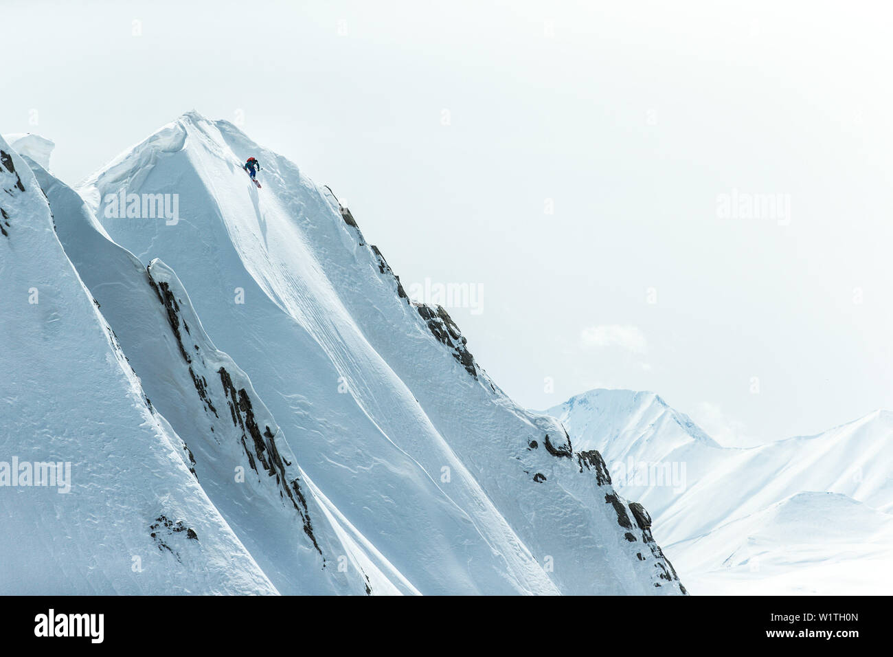 Young male skier riding apart the slopes through the deep powder snow ...