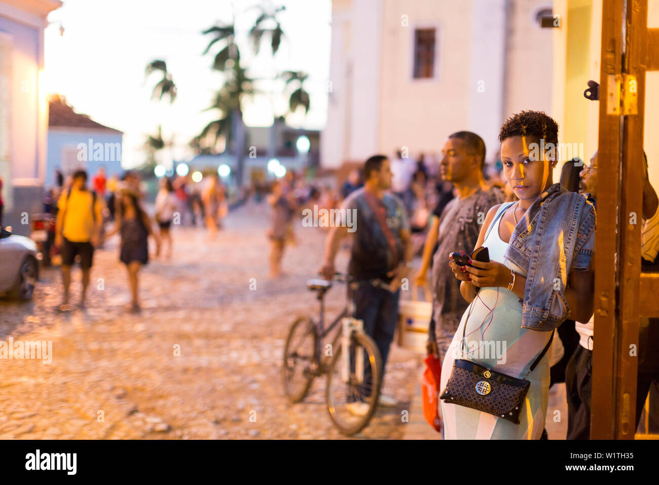 beautiful Cuban woman on her mobile at the terraces of Trinidad, next ...