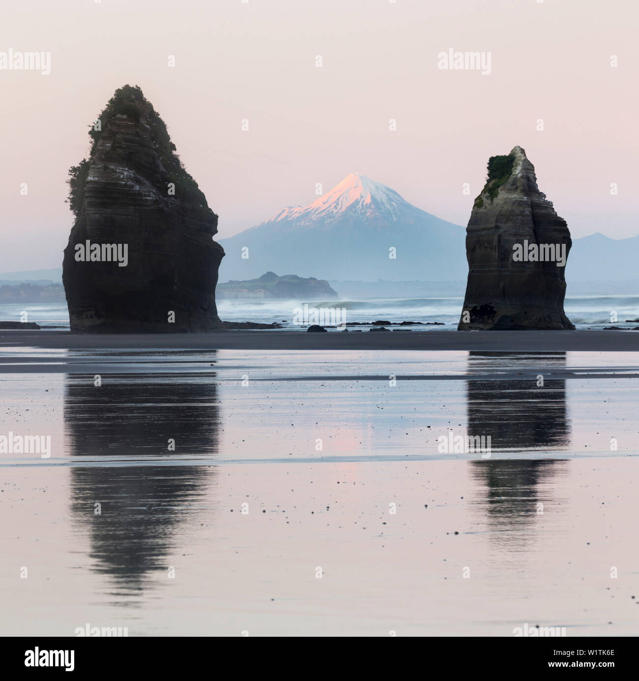 Rock formations and view of Mount Taranaki volcano, Tongaporutu ...