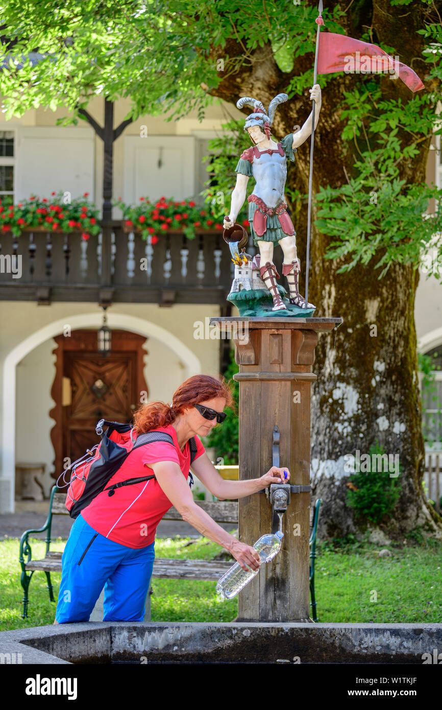 Woman hiking on Lechweg standing at fountain of Saint Florian and ...