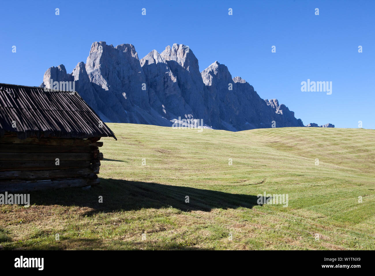 Small wooden hay cabin in front of the Geisler peaks, Dolomites, South ...