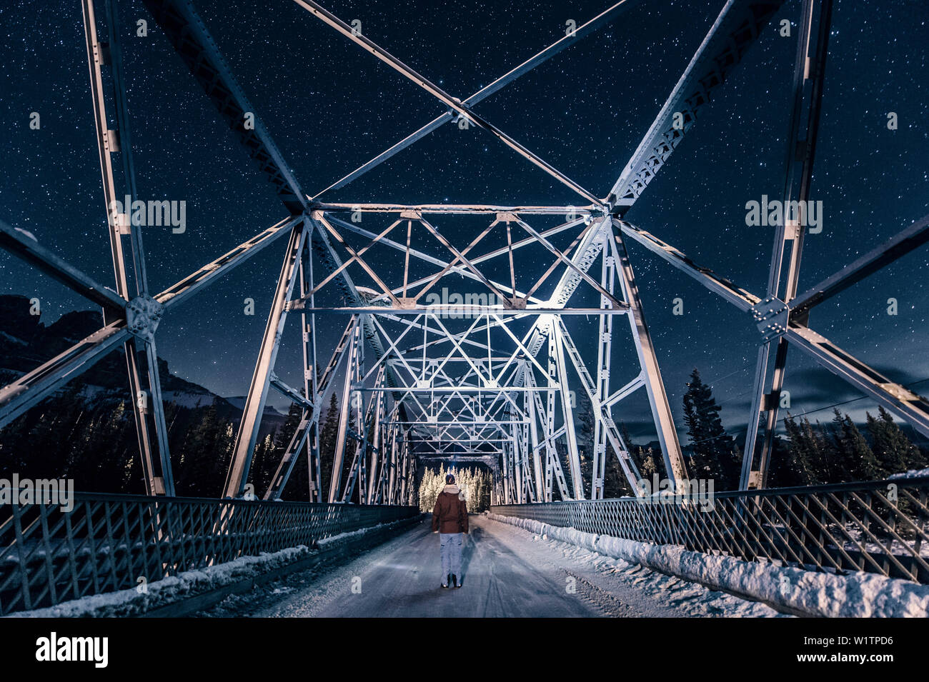 Man standing on a Bridge over Bow River at night, castle junction ...