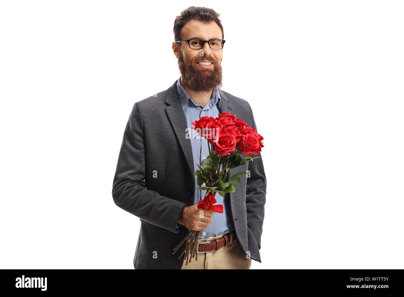 Bearded young man in a holding a bunch of red roses and smiling ...