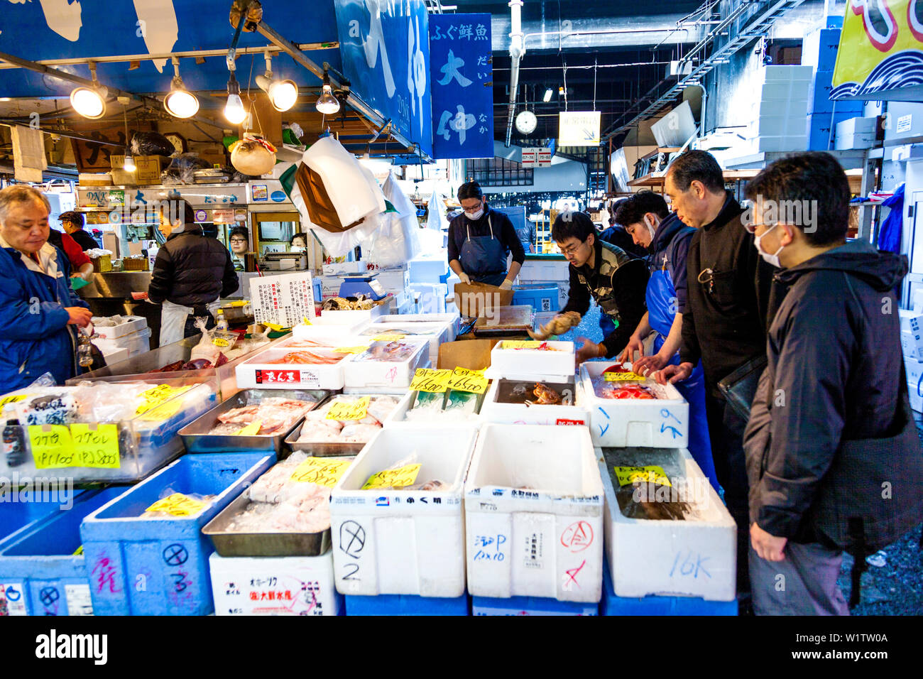 People buying from seafood vendors at Tsukiji Fish Market in Tokyo ...