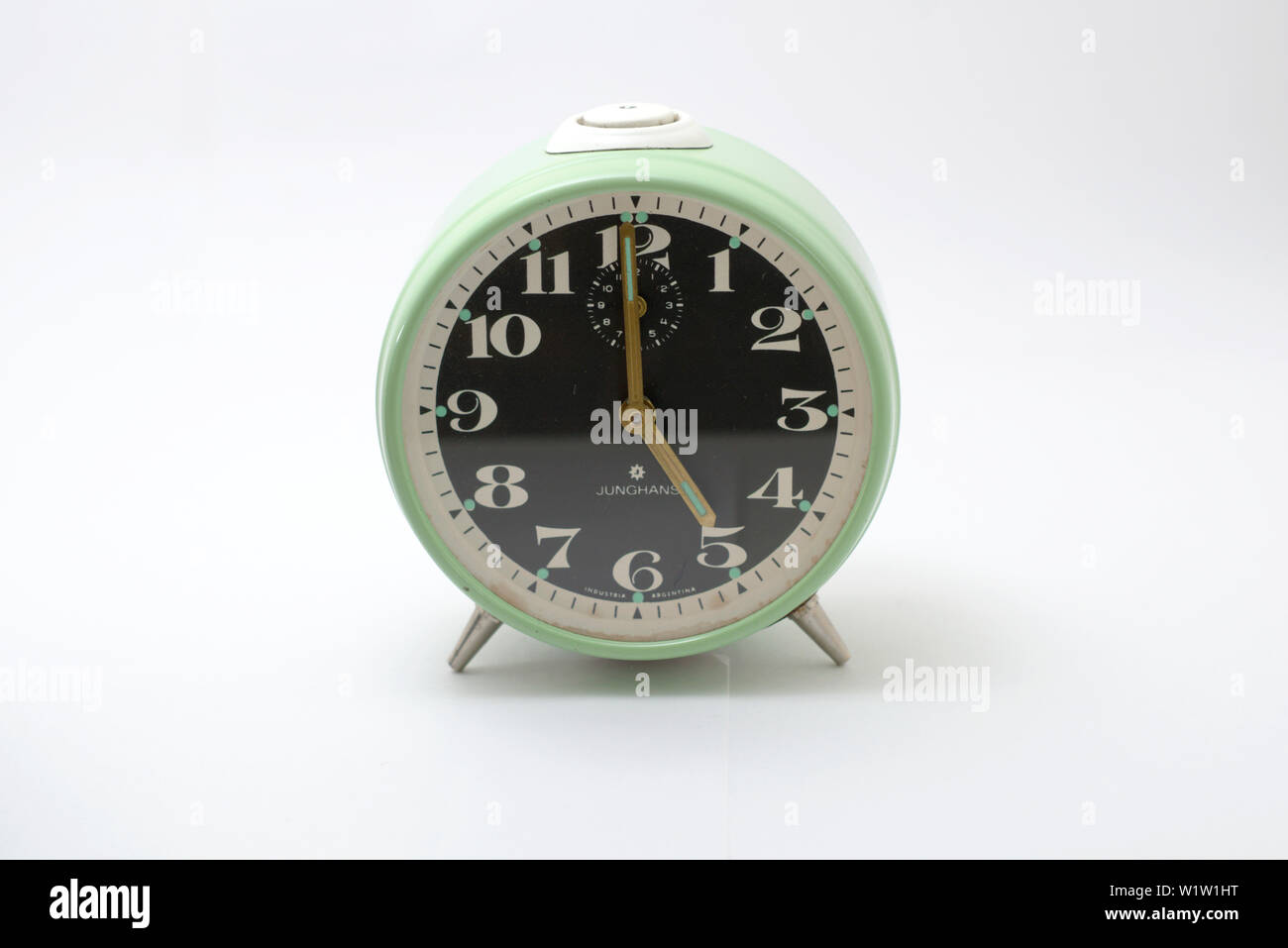 An old mechanical alarm clock, showing five o'clock Stock Photo - Alamy