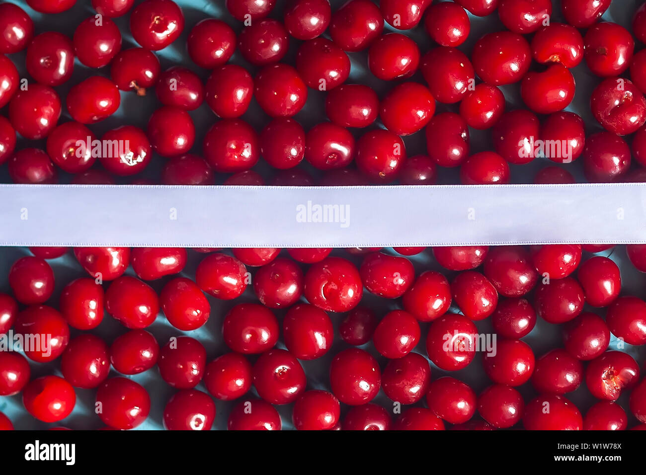 Cherry background with white ribbon. Fresh organic berries. Pile of ...