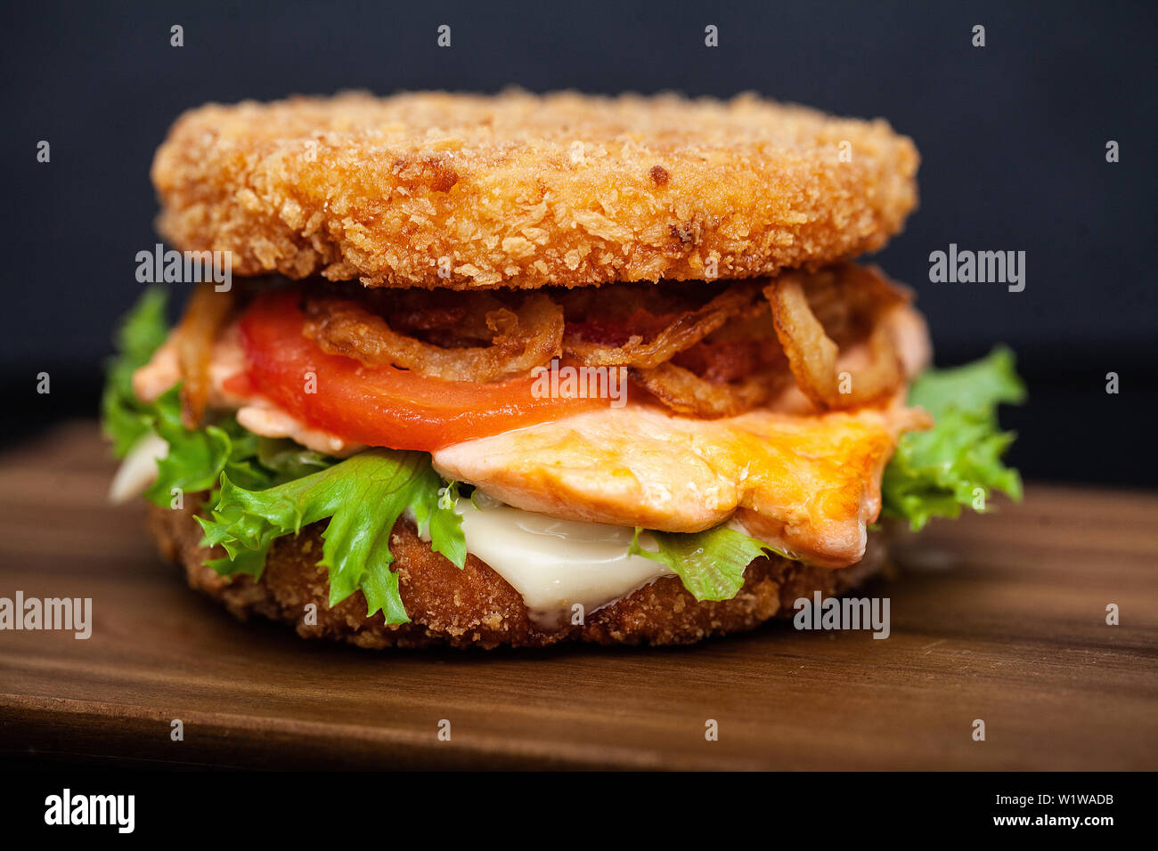 Sushi Burger with a variety of tasty ingredients on a dark background ...