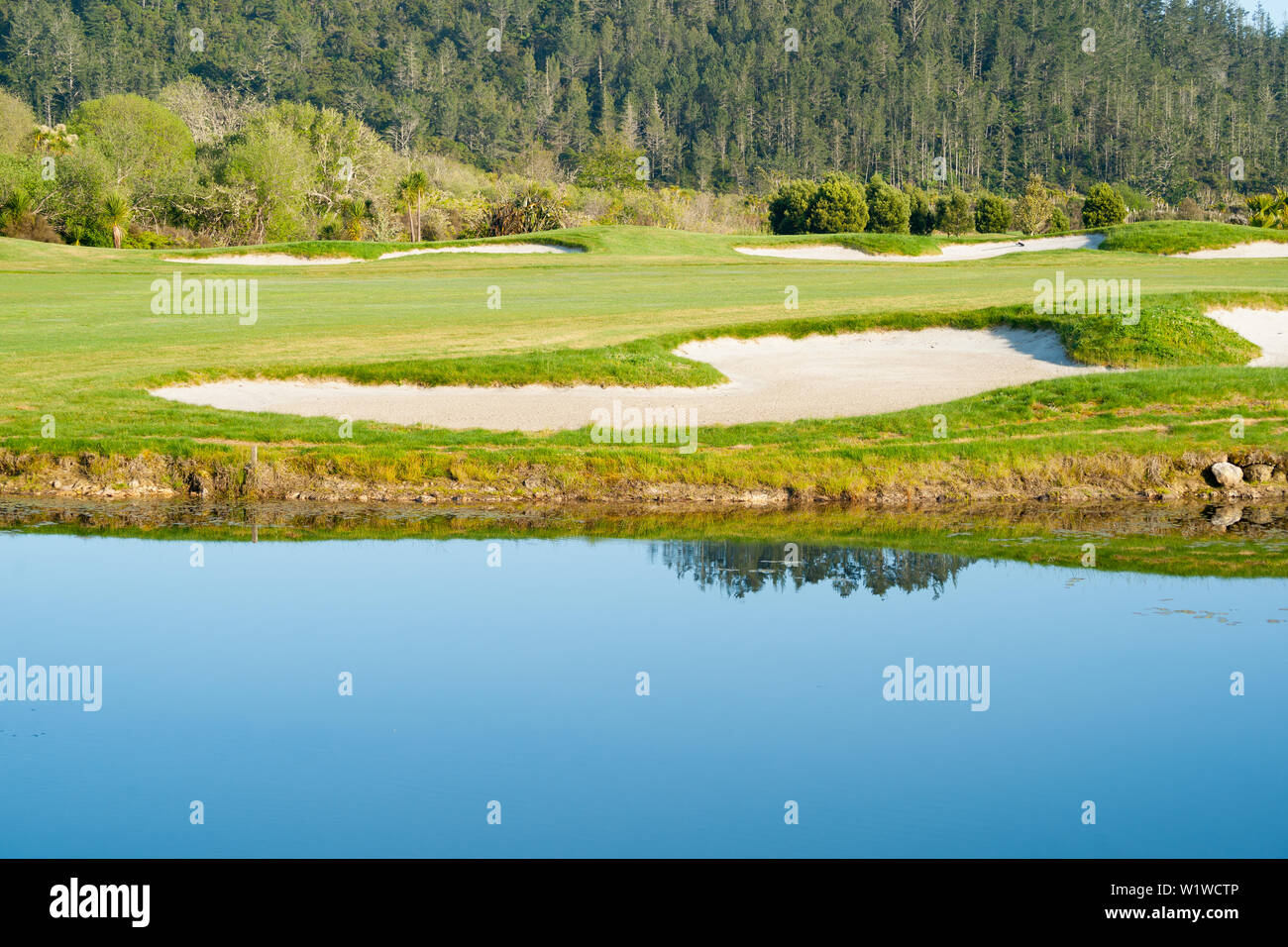 Sand-traps and blue pond on golf course Stock Photo - Alamy