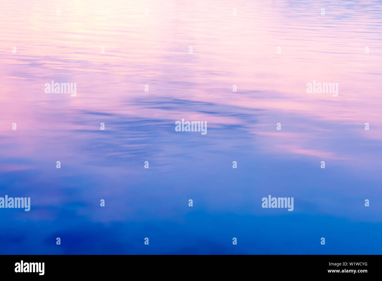 Abstract blue water background and reflected pink sky Stock Photo - Alamy
