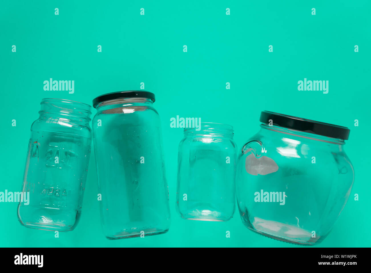 Isolated glass jars laid flat and center on teal mint green background ...