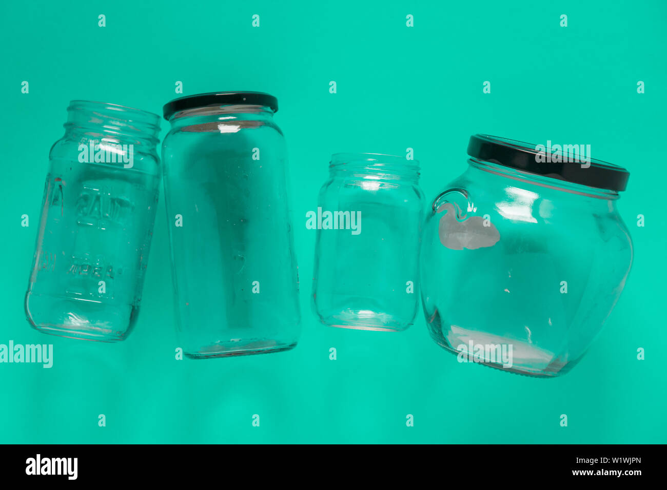 Isolated glass jars laid flat and center on teal mint green background ...
