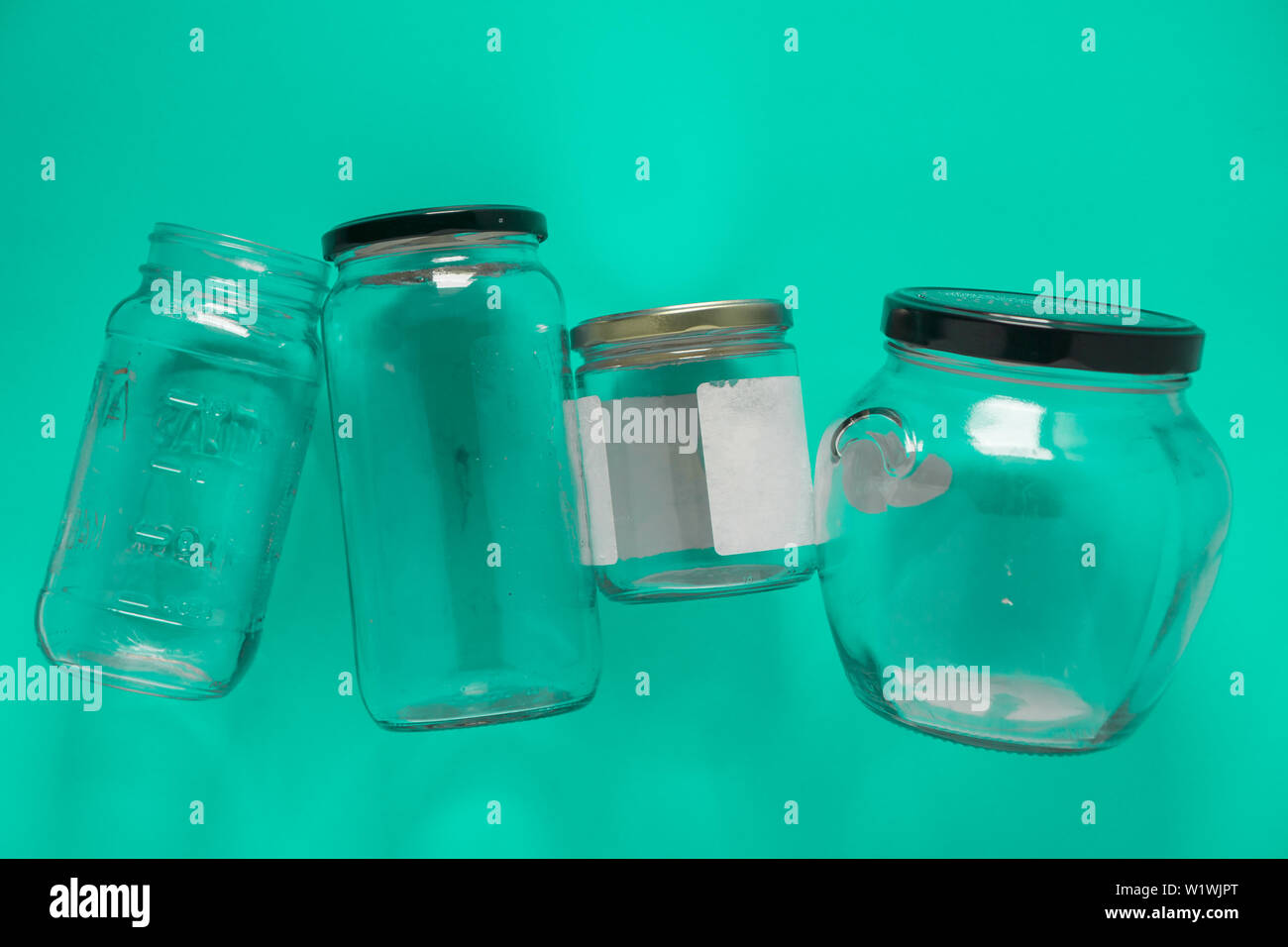 Isolated glass jars laid flat and center on teal mint green background ...