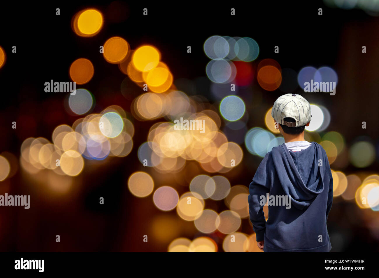 Asian boy see blurred lights of the house and street light, bright ...