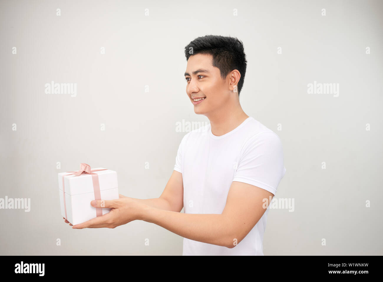 A happy handsome man presenting some gifts. Isolated on white ...