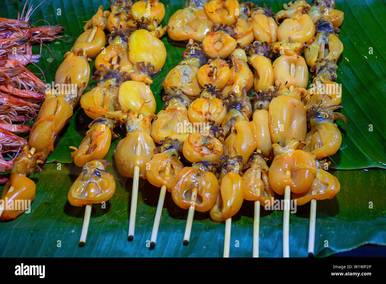 Grilled marinated squid with seafood sauce On banana leaf With the heat ...