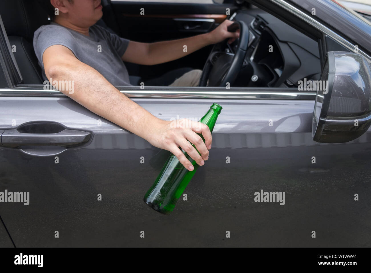 Don't Drink for Drive concept, Young Drunk man drinking bottle of beer ...