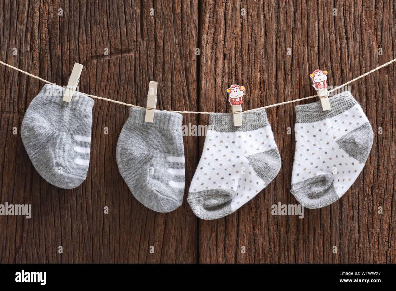 new baby socks hanging on clothesline over wood background, newborn and ...