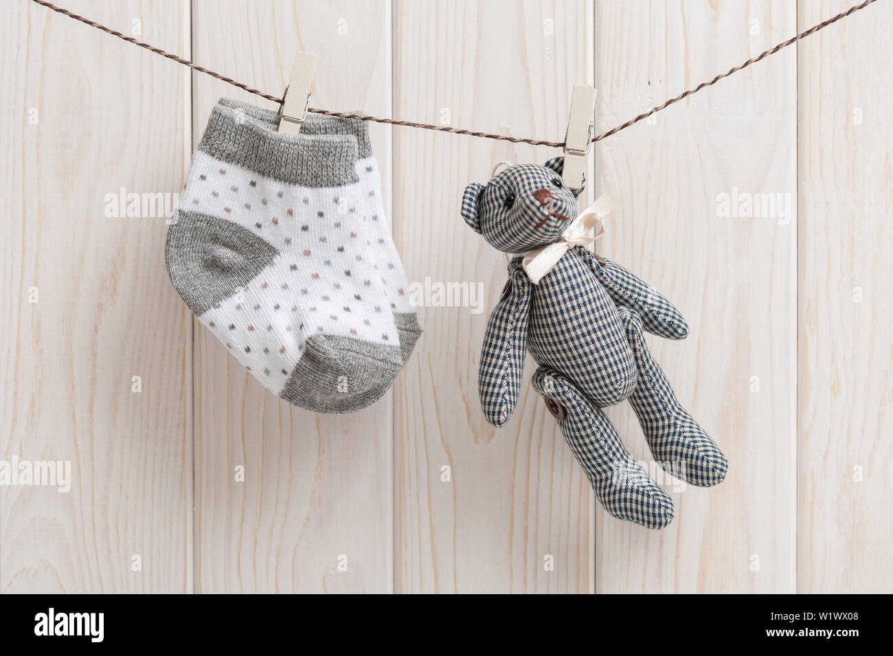 new baby socks hanging on clothesline over wood background, newborn and ...