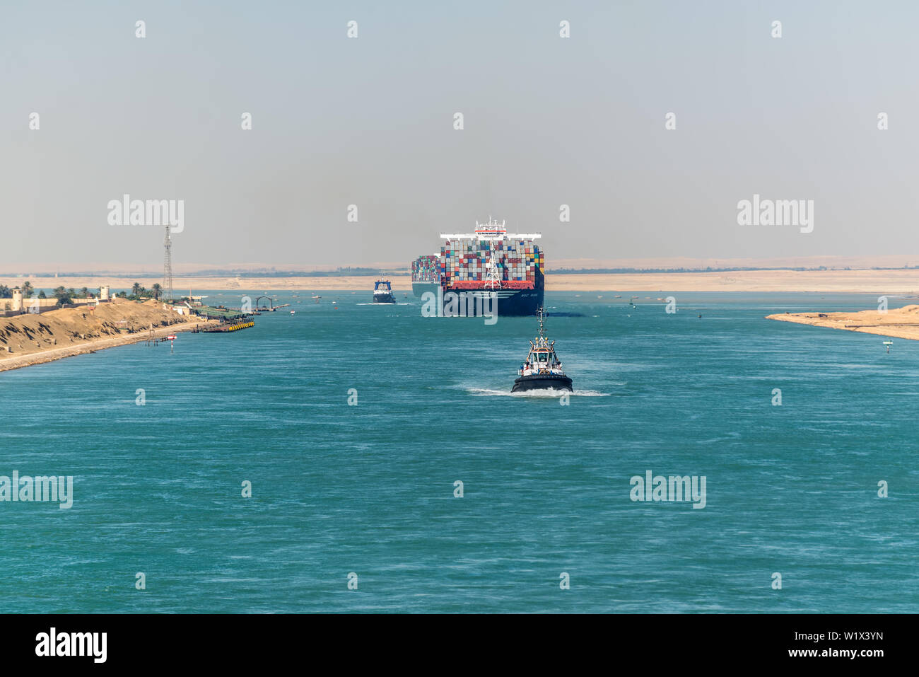 Suez, Egypt - November 5, 2017: Large container vessels (ships) passing Suez Canal in the sandy ...