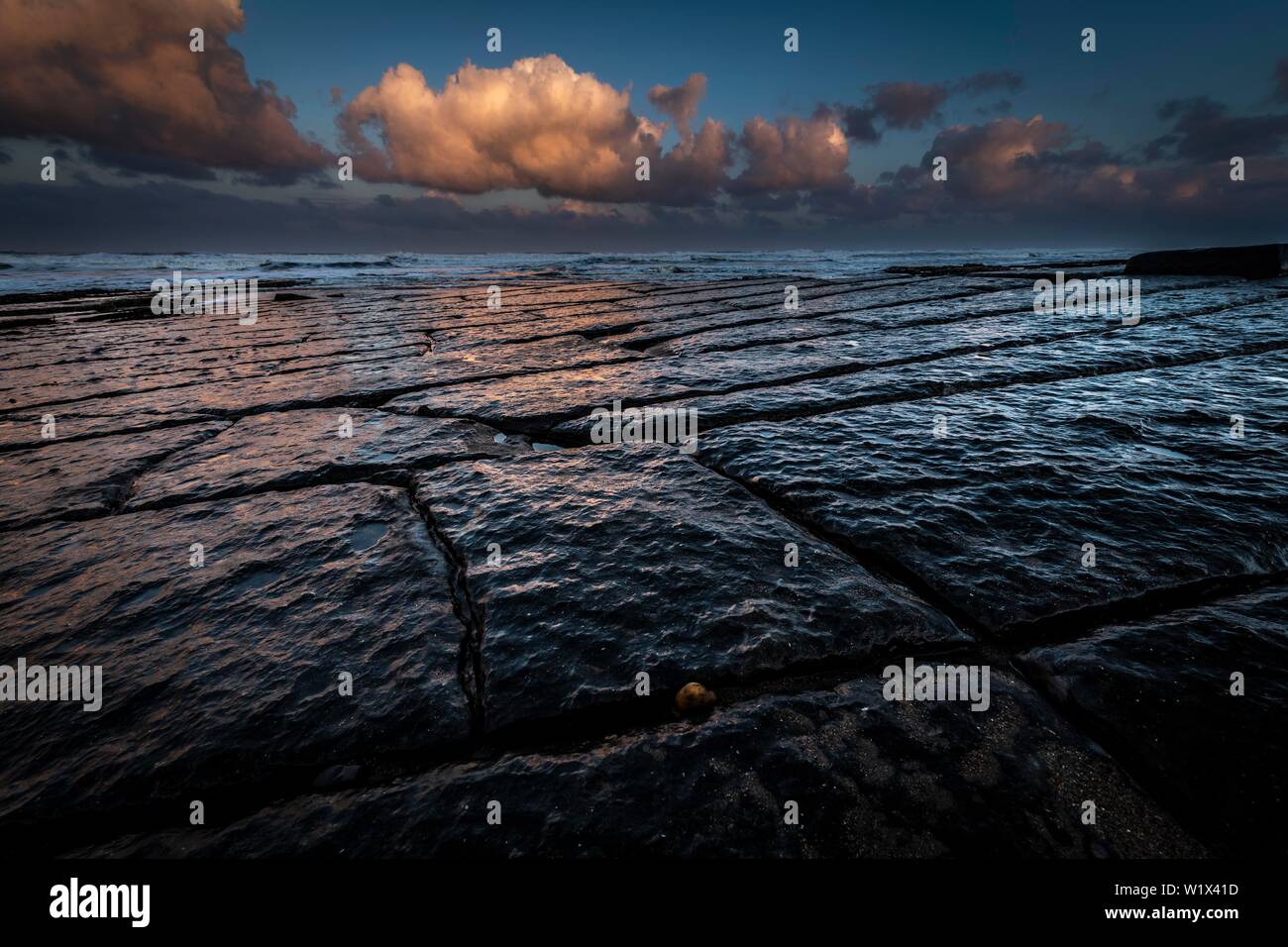 Coast with granite rocks washed by the sea in the evening light ...