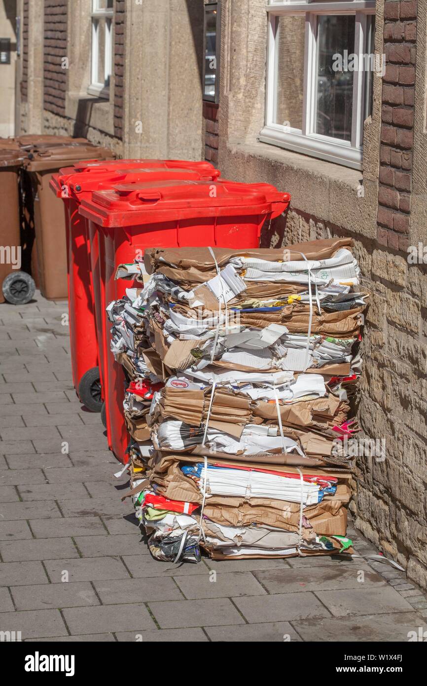 Red bins for waste glass and stacks of waste paper, Germany, Europe ...