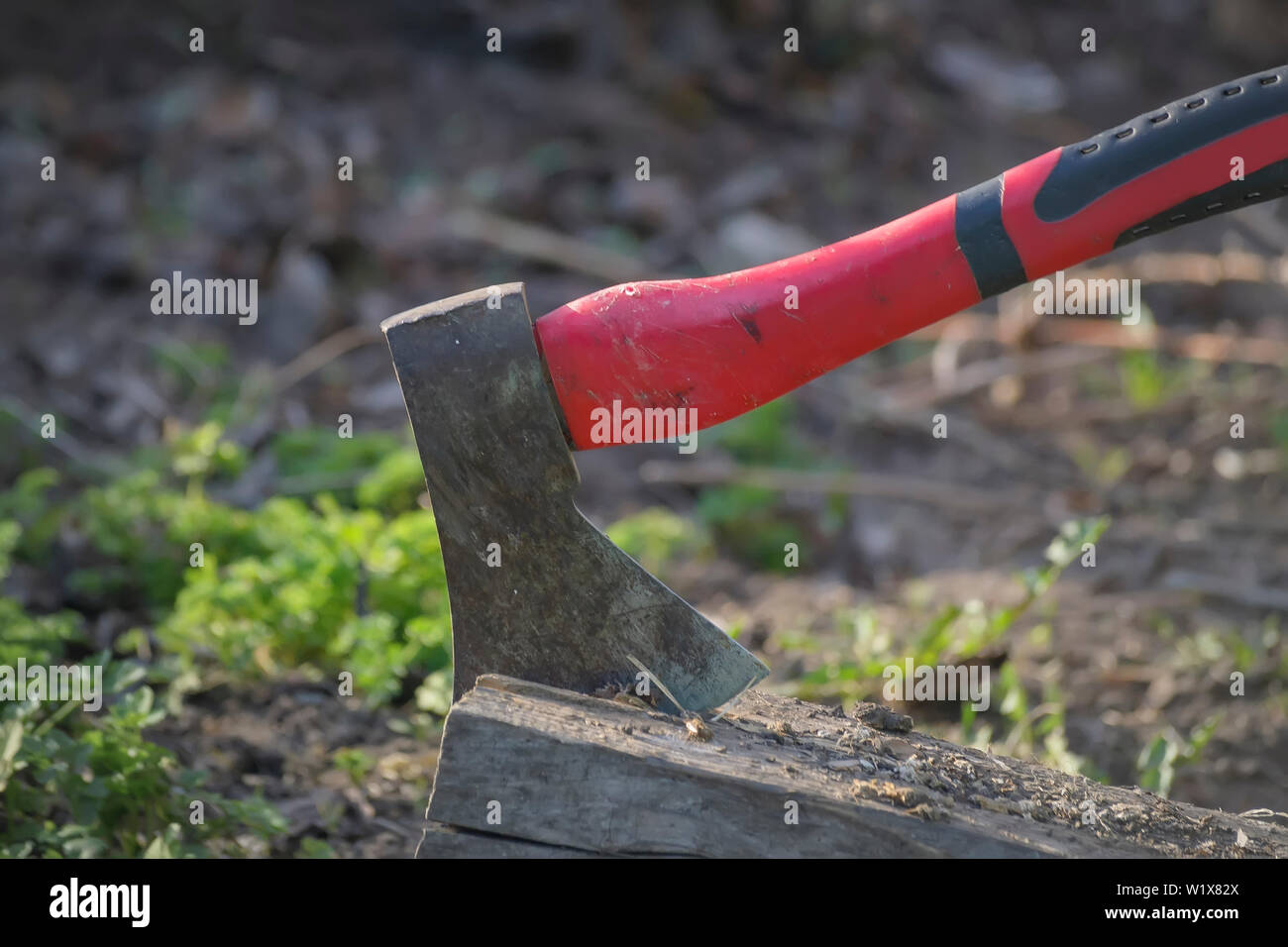 Ax in the beam. Ax with red black handle Stock Photo - Alamy