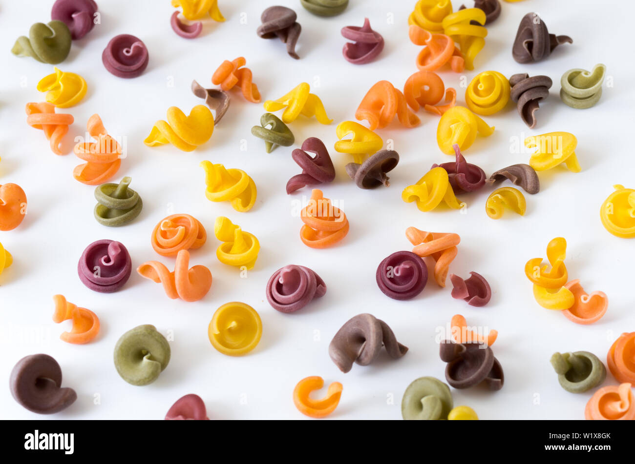 Texture with deep shadows. Multicolored pasta on a white background ...