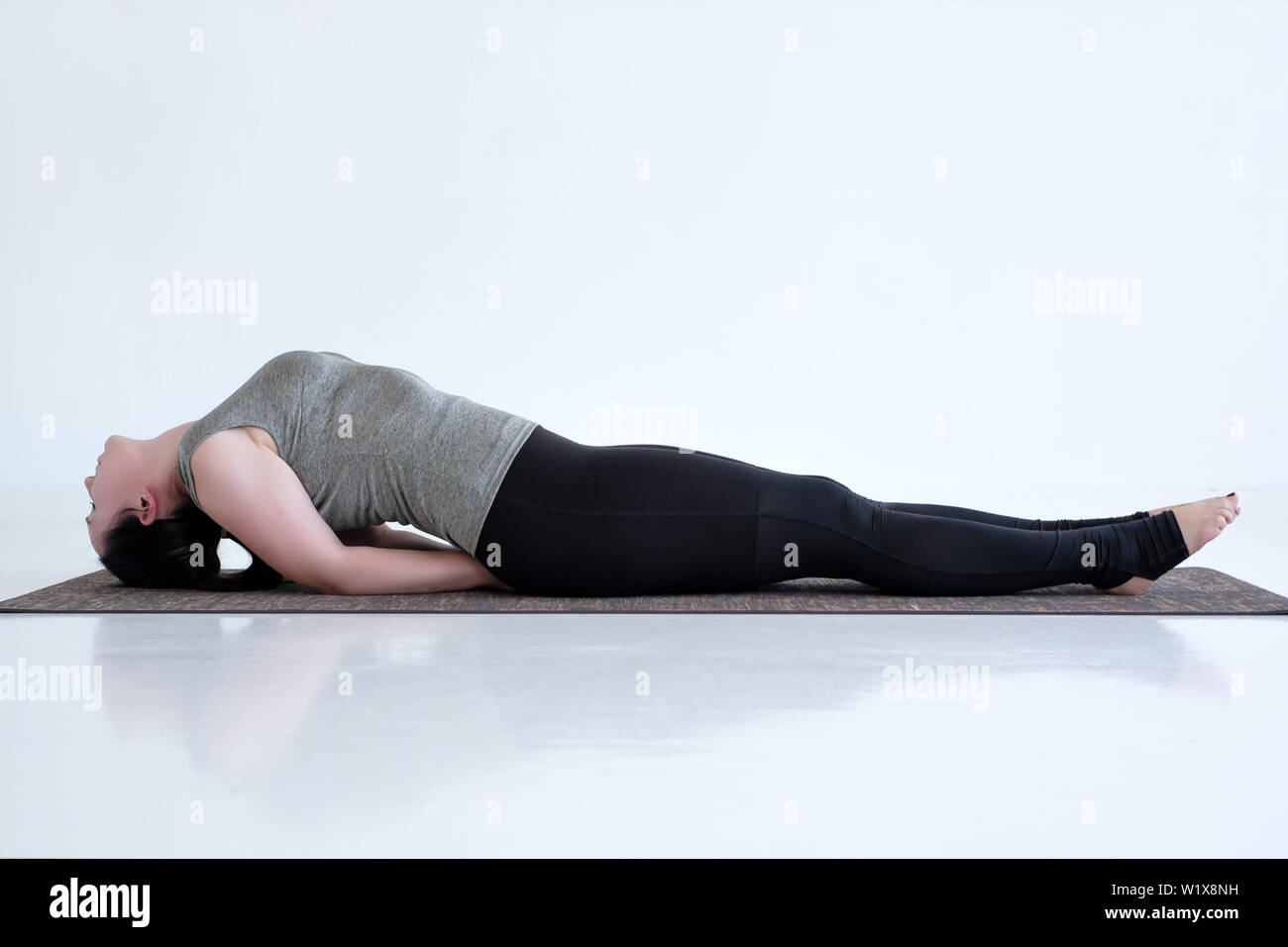 Woman practicing yoga, doing Matsyasana exercise, Fish pose Stock Photo ...