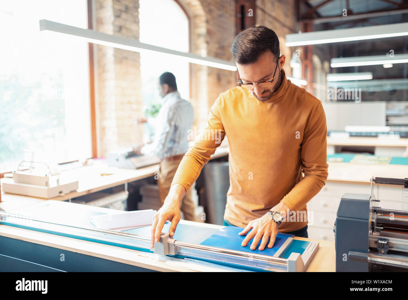 Paper manufacturing office. Handsome dark-haired man wearing glasses ...