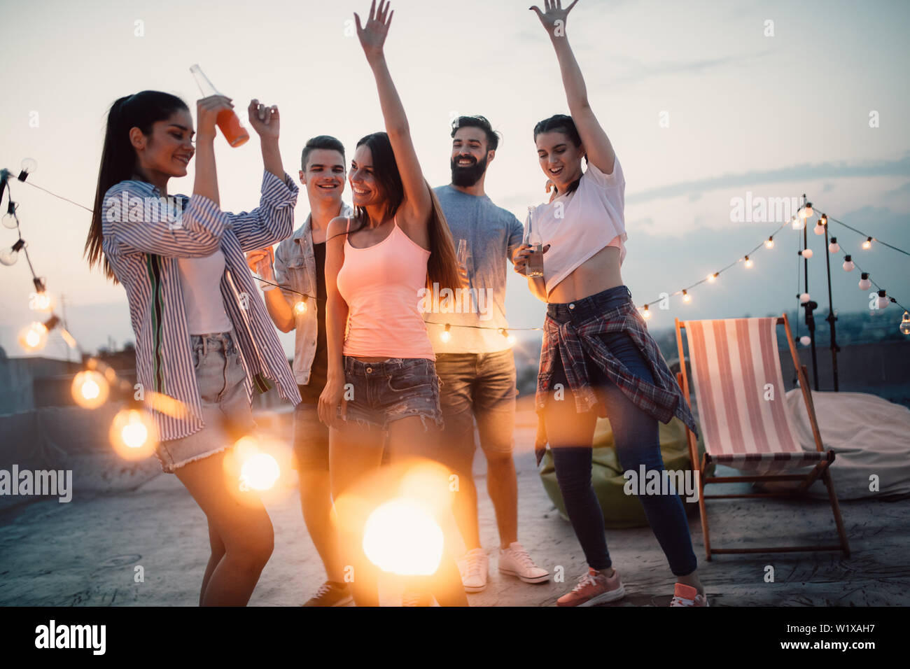 Group of happy young friends having party on rooftop Stock Photo - Alamy