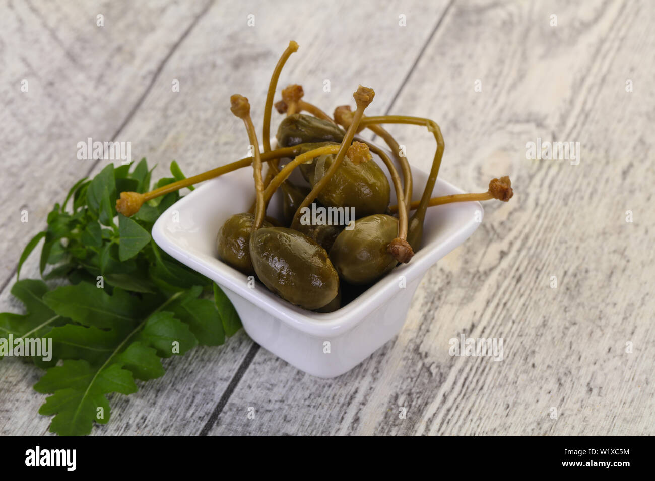 Pickled Capersberries in the bowl with basil Stock Photo - Alamy