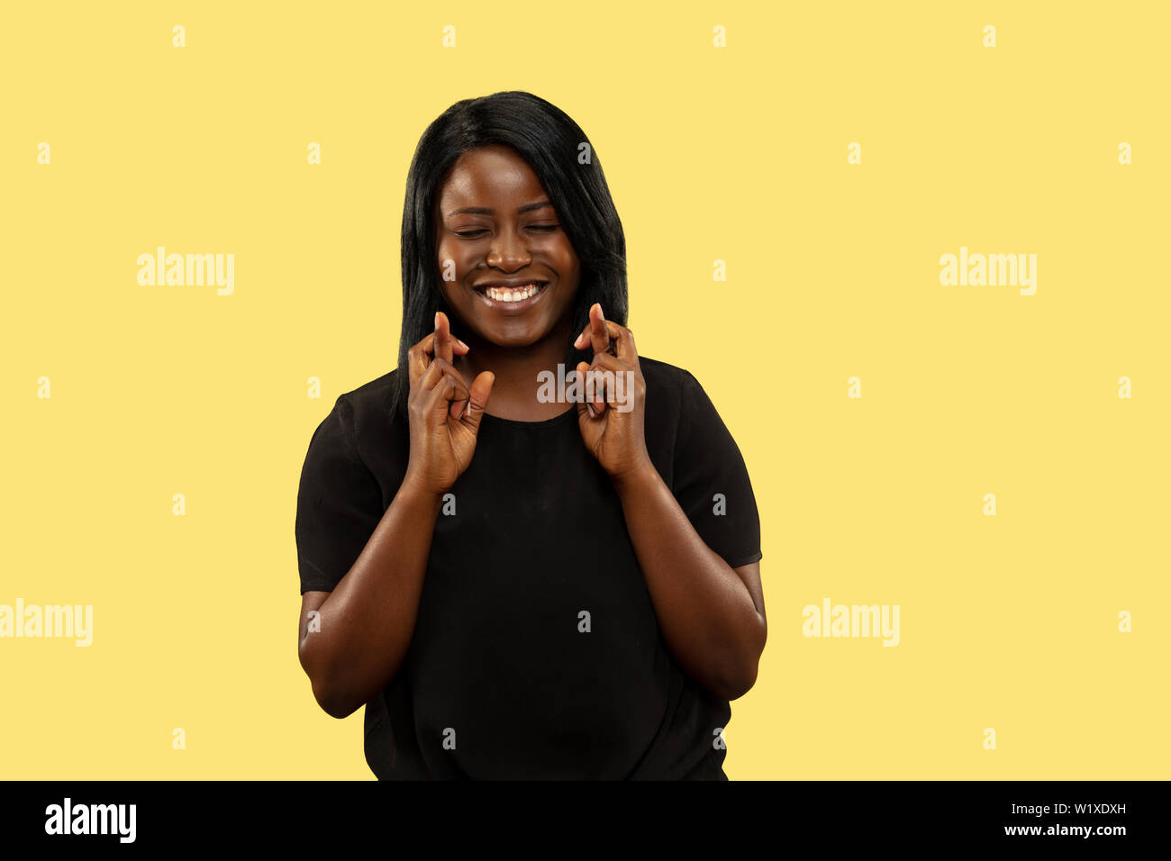 Young african-american woman isolated on yellow studio background ...