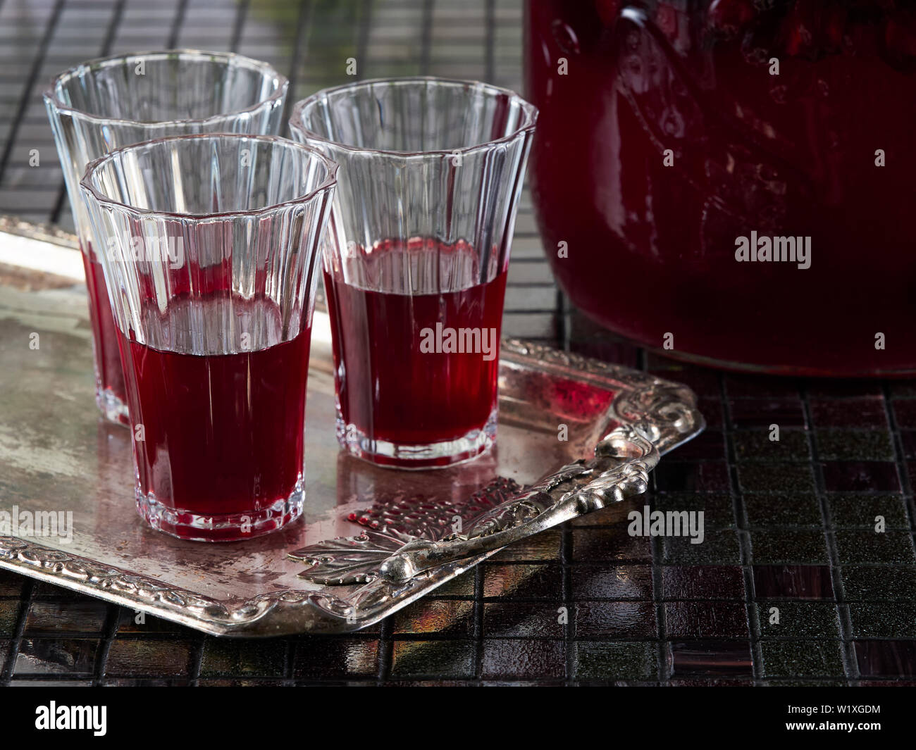 Sour cherry liqueur in crystal glasses and a jar of homemade sour ...
