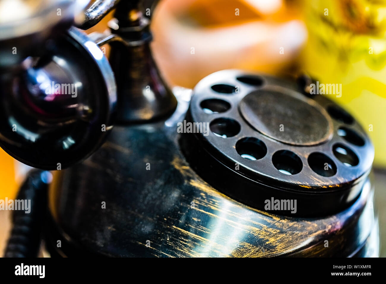 A close up image of an antique telephone. The dial is the prominent ...