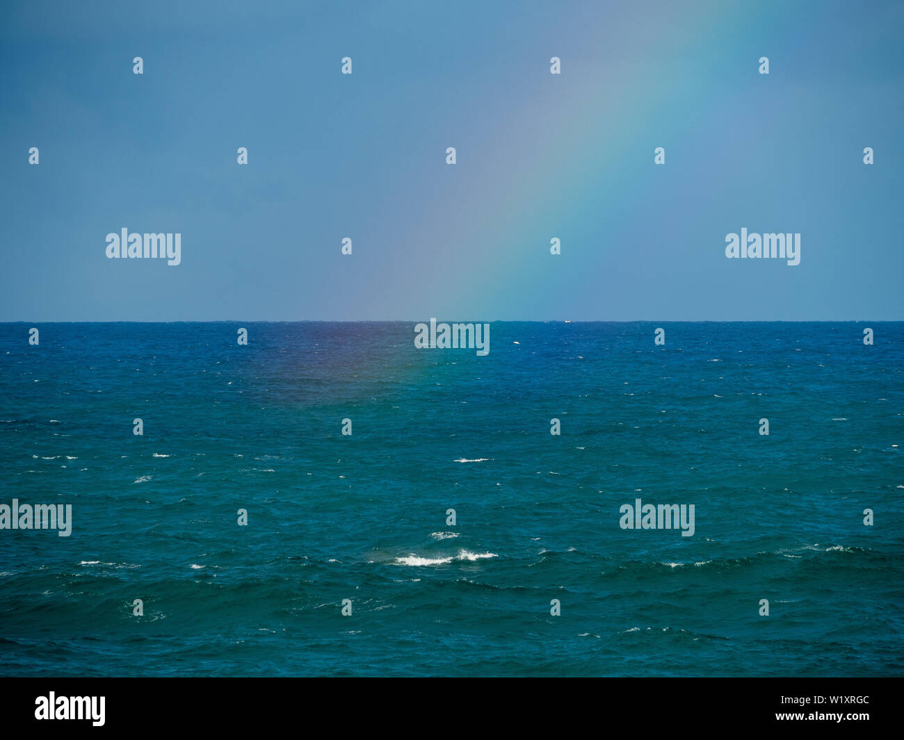 a beautiful Rainbow ending in the sea, fading Stock Photo - Alamy